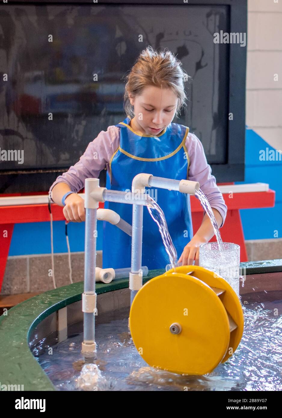 A young girl learns how water flows and how to direct it, as she plays ...
