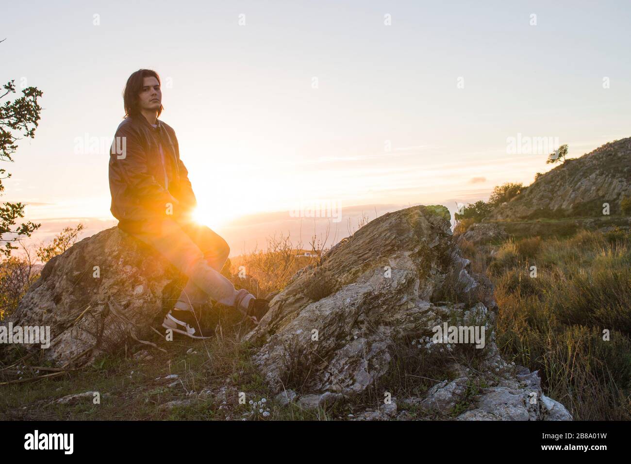 Guy sitting on a rock hi-res stock photography and images - Alamy