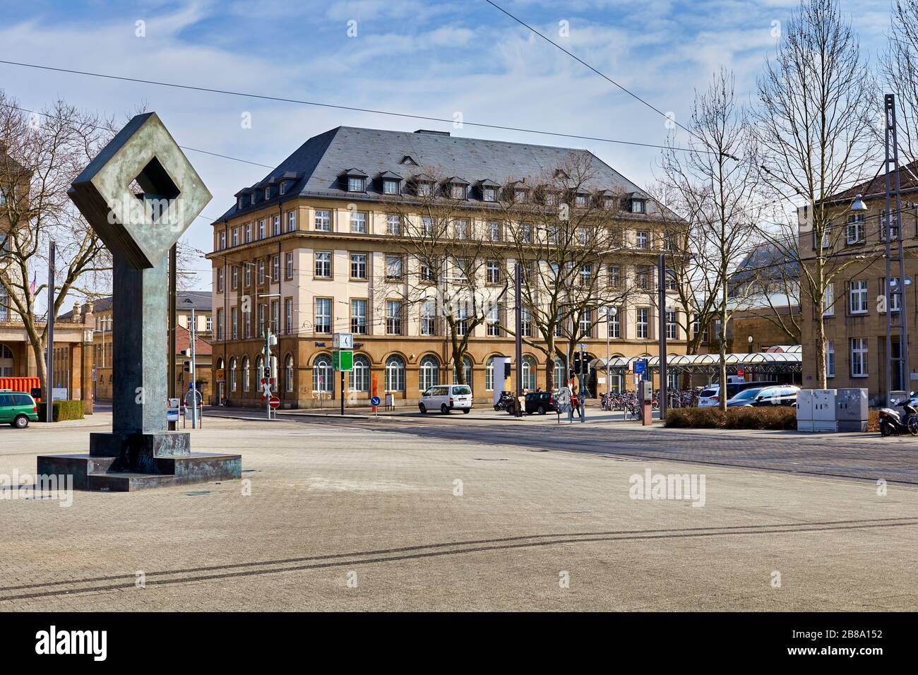 An old, historic building in a large square with a sculpture Stock ...