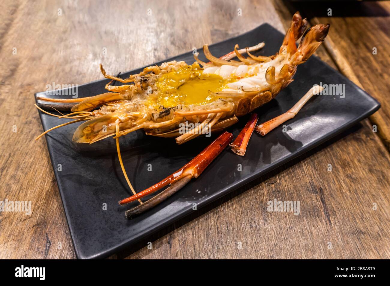 Fresh grilled river prawns with a lot of fat on the head resting on a ...