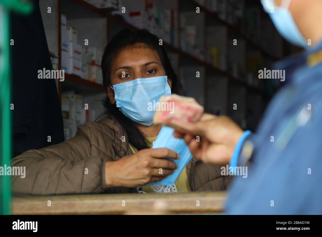 Kathmandu, Nepal. 20th Mar, 2020. Pharmacists selling face mask to the ...