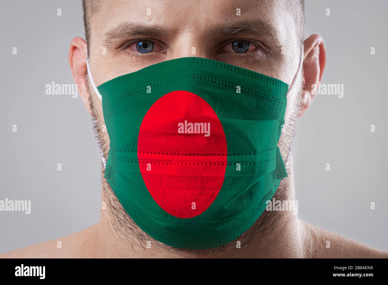 Young man with sore eyes in a medical mask painted in the colors of the ...