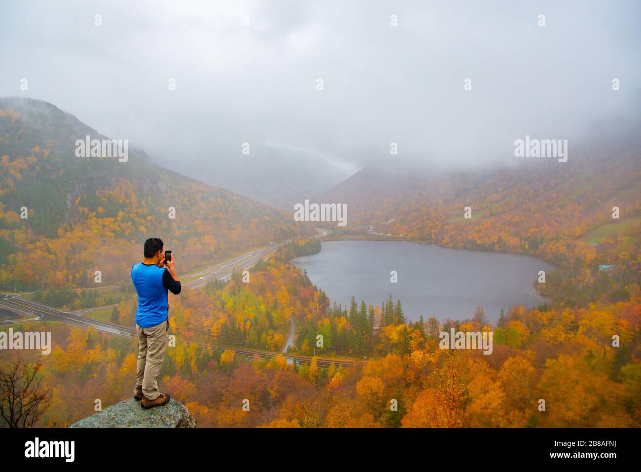 Man taking photo of Echo Lake from Artists Bluff Loop in New Hampshire ...