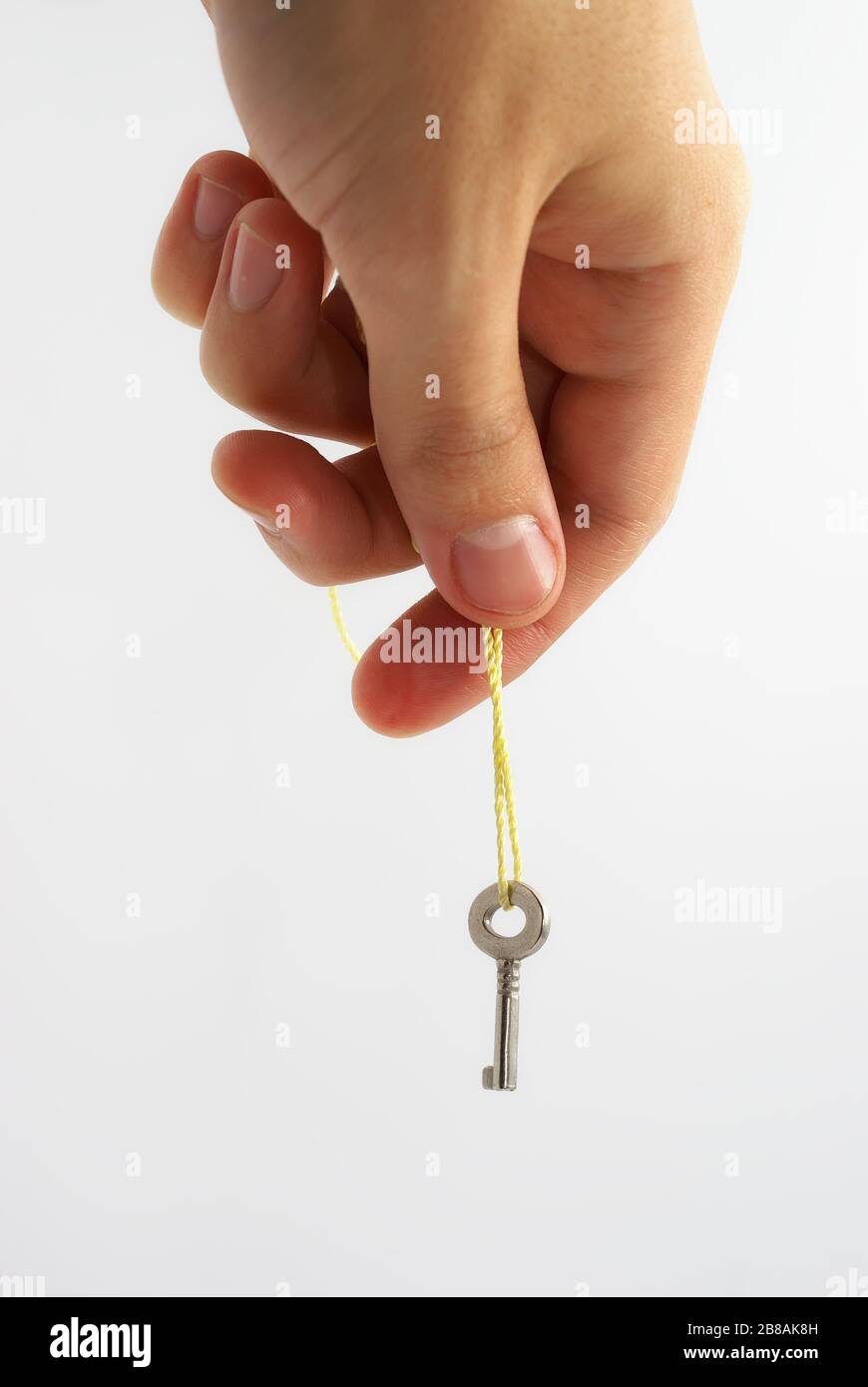 Hand holding a rope with a small key. Isolated object design Stock ...