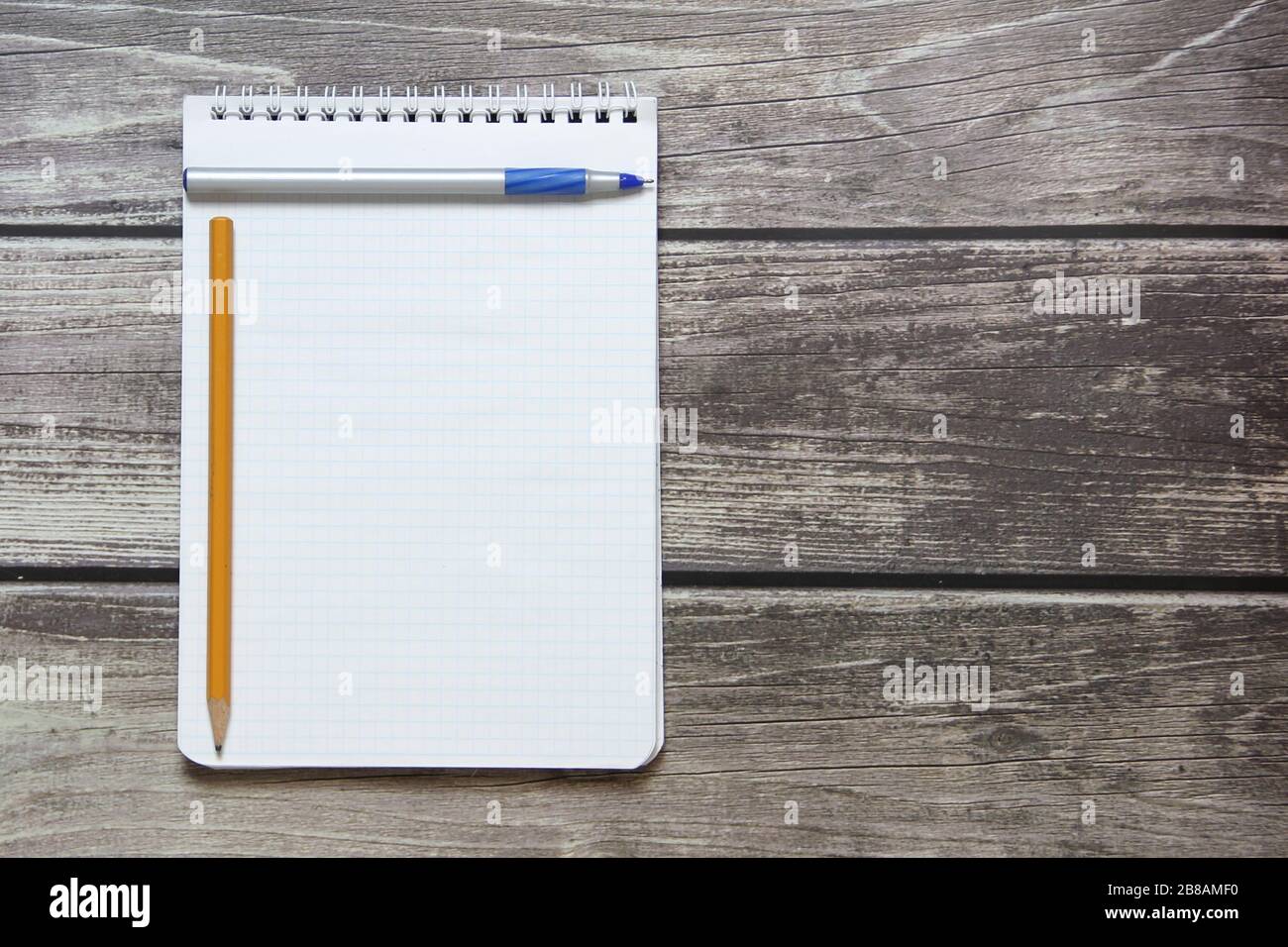 Notepad with a blank white sheet in a checker paper with ball pen and ...