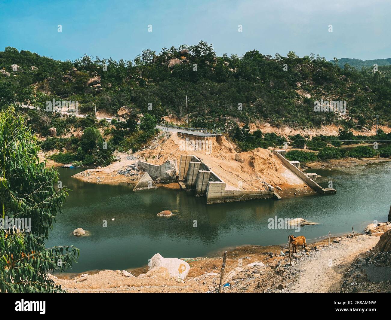 The destroyed bridge over the mountain river. Concrete bridge collapsed ...