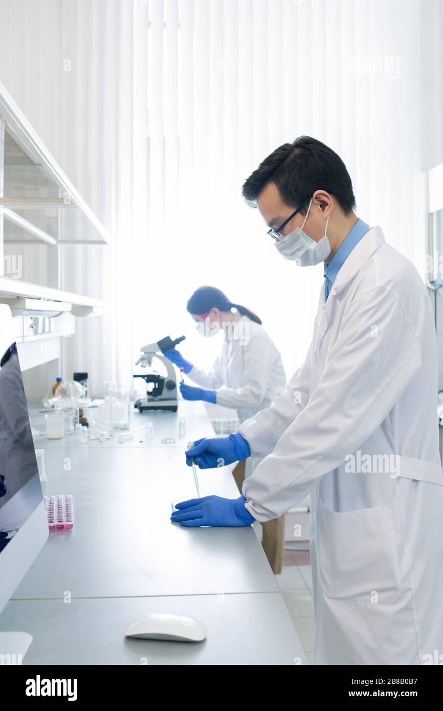 Asian lab technician on microscope hi-res stock photography and images ...