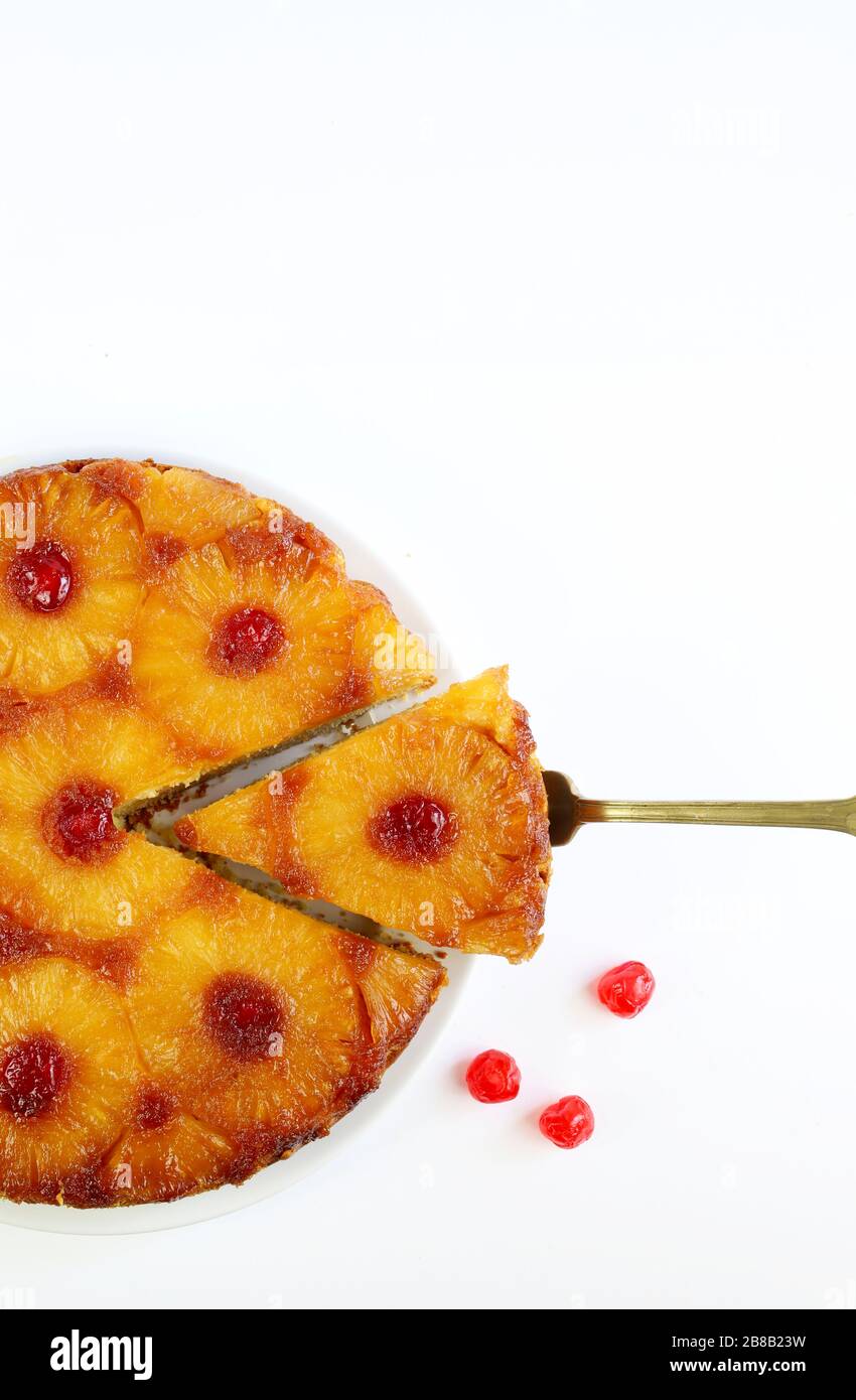 Cutted Pineapple upside down cake with glacé cherry and scapula on ...