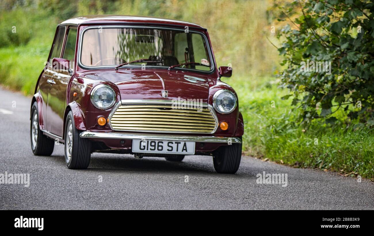 red classic mini on country road Stock Photo - Alamy
