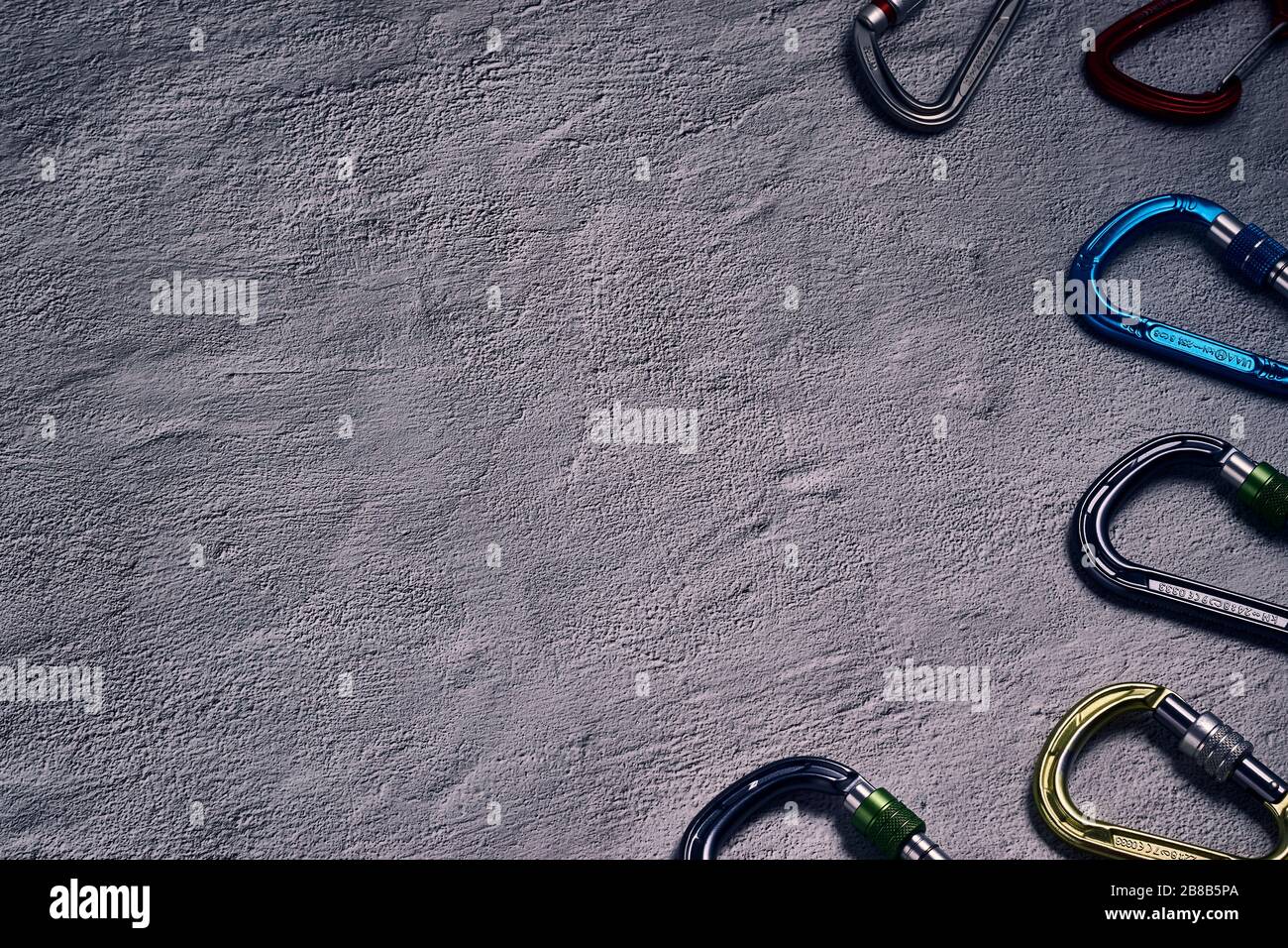 Overhead closeup shot of different colored carabiners on a concrete ...