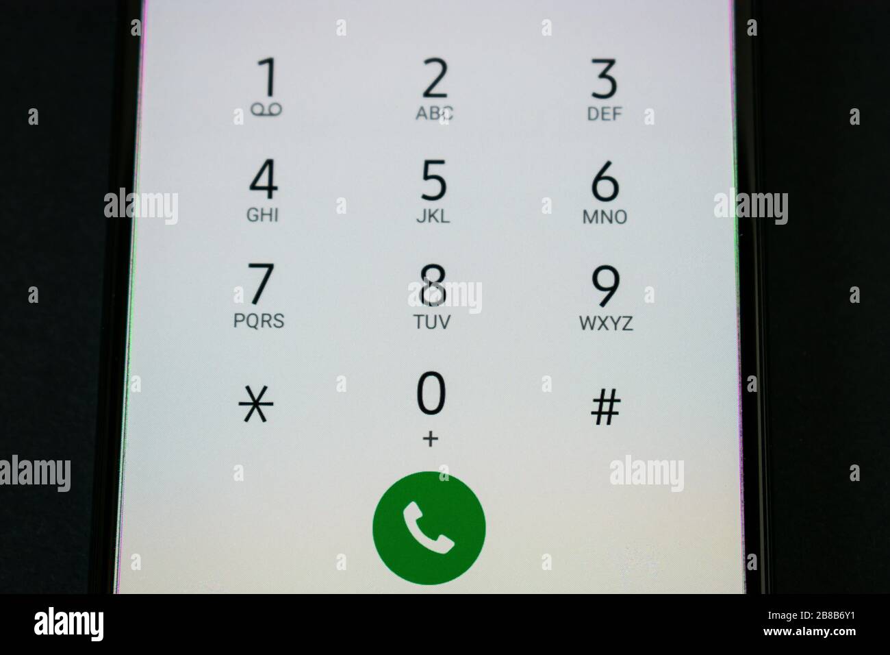 Smartphone keypad with black numbers on white background, close up ...