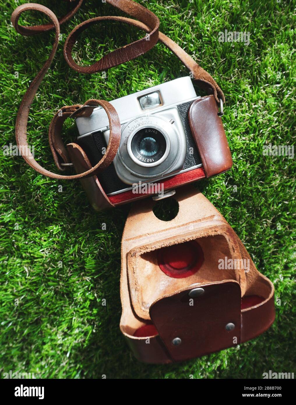 Vertical shot of a camera in a leather case on the grass Stock Photo ...