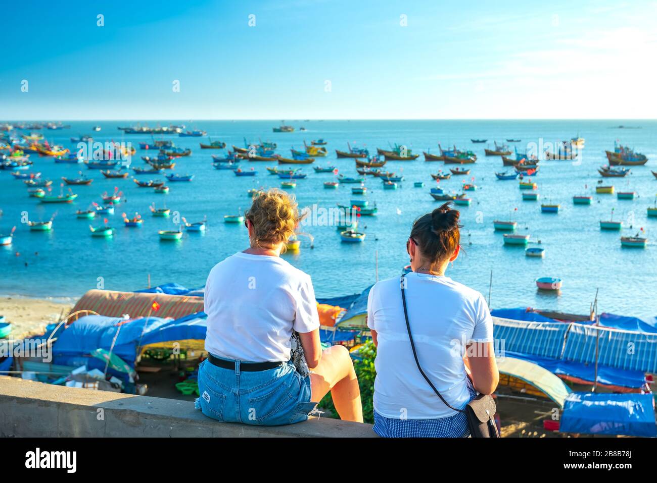A couple of foreign tourists sit and relax inside embankment bay with ...