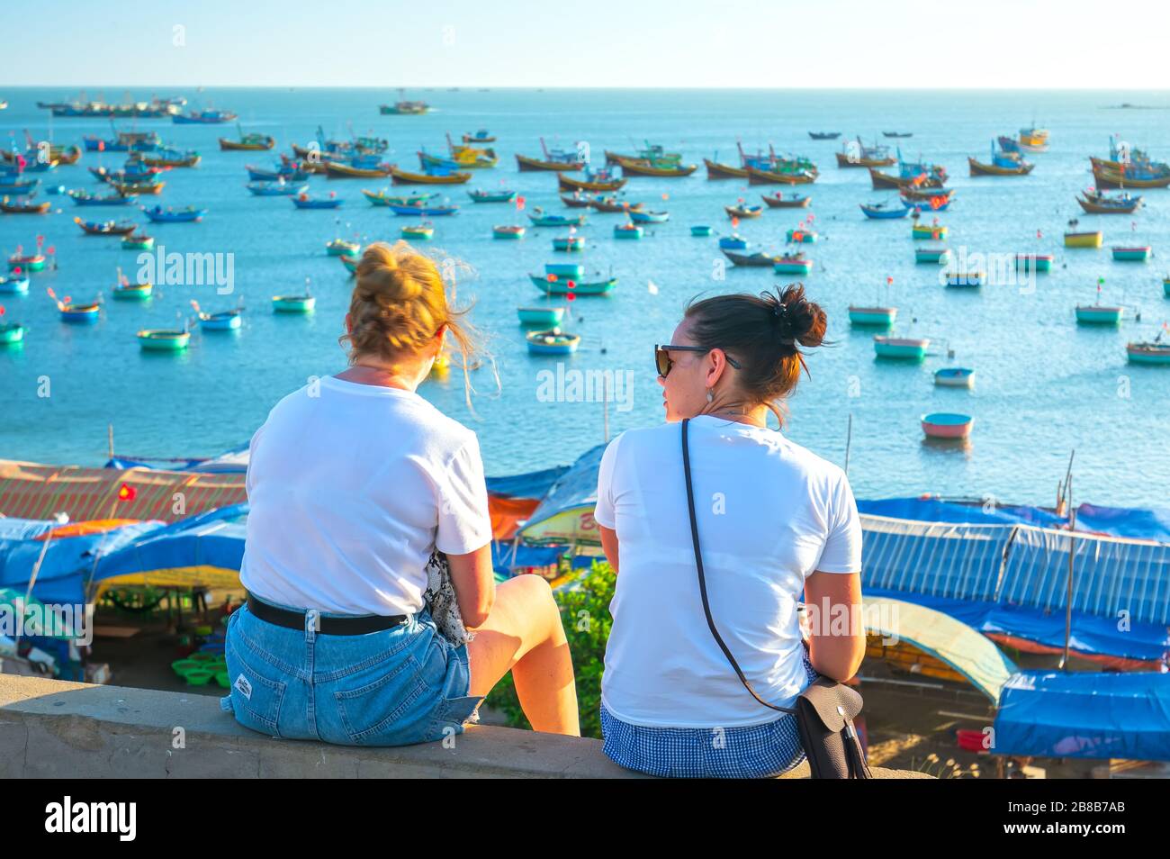 A couple of foreign tourists sit and relax inside embankment bay with ...