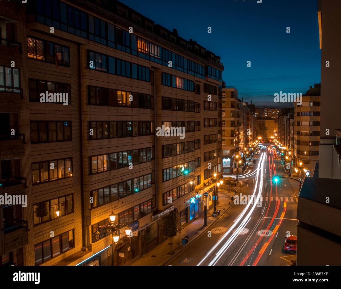 Large building surrounded by others in front of the street Stock Photo ...