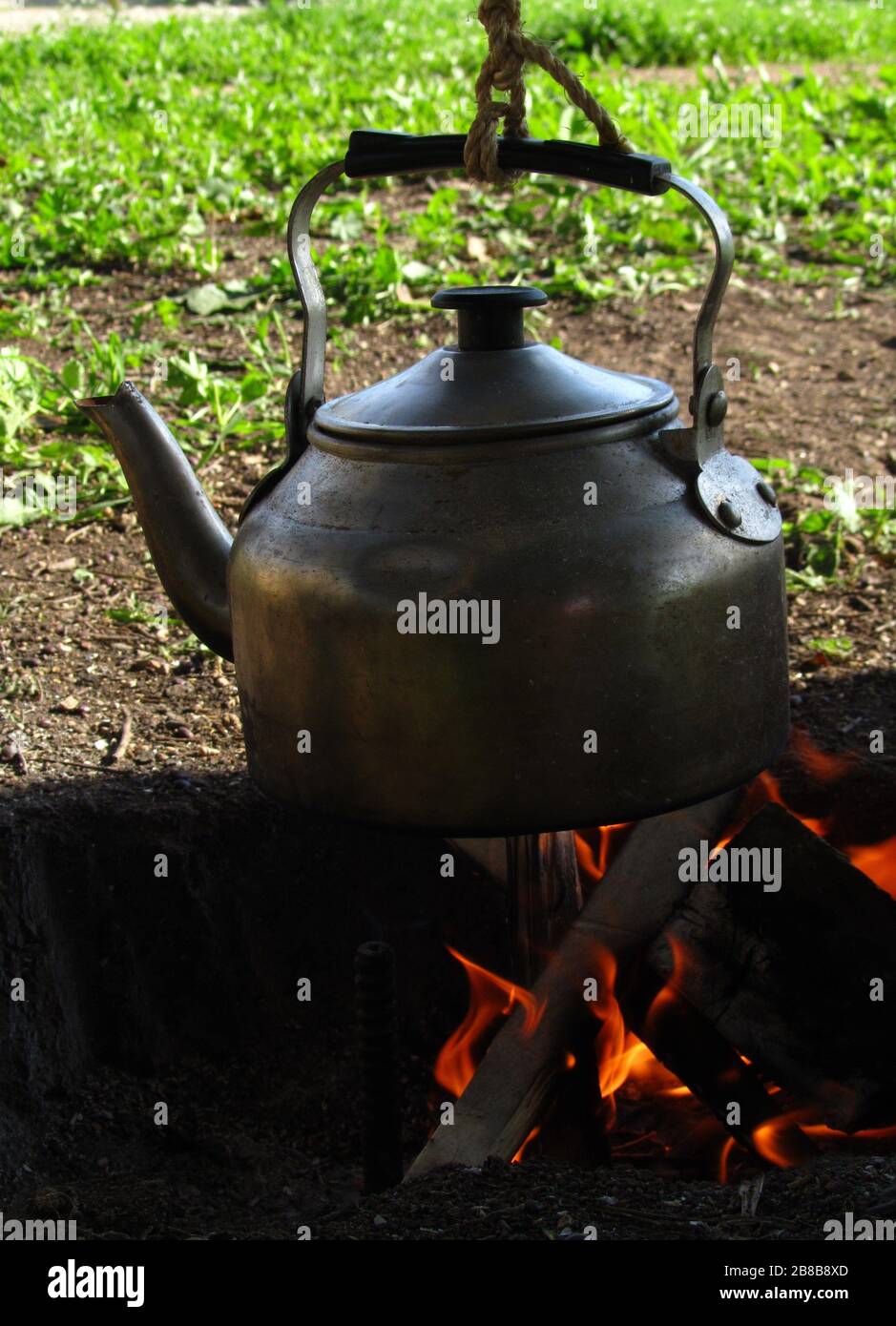 Closeup shot of a kettle of water over a fire for coffee and tea during ...