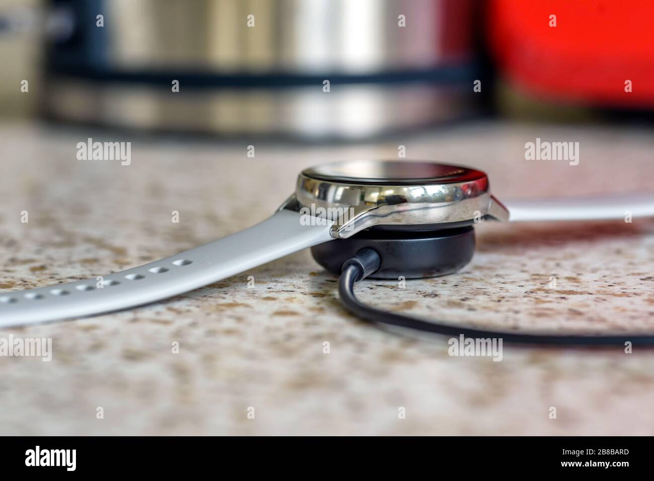 smart watch wireless charging on charging pad on kitchen worktop table ...