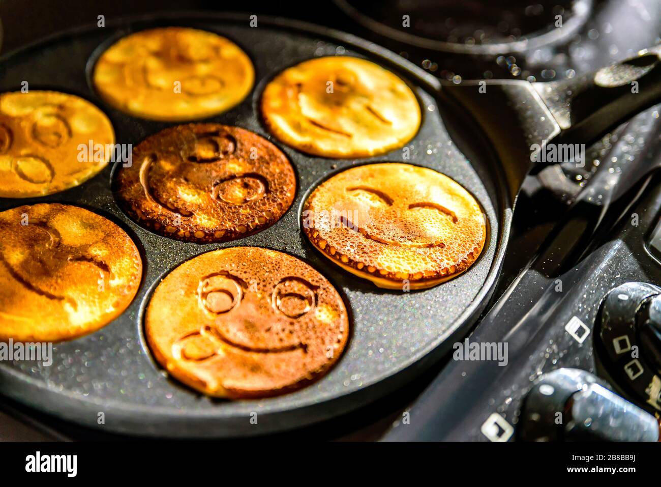 pancake frying pan with smile face pancake cooking on cooker in kitchen ...