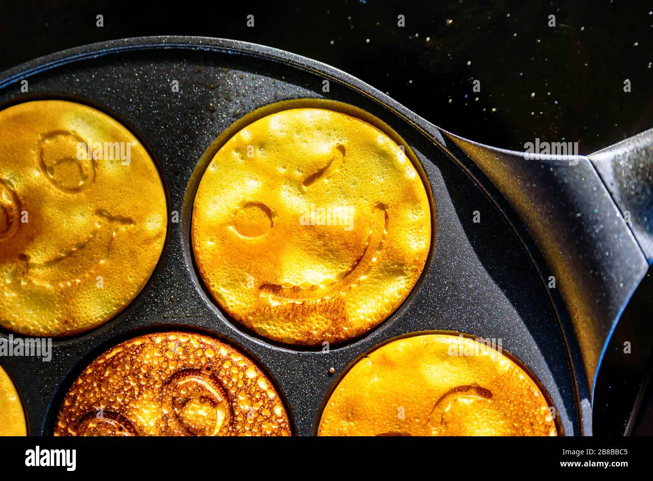 pancake frying pan with smile face pancake cooking on cooker in kitchen ...