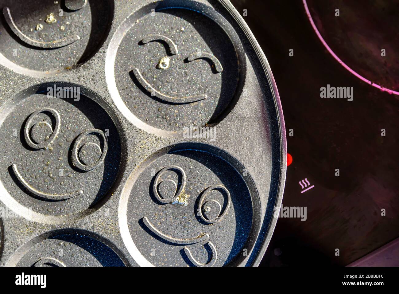 pancake frying pan with smile face pancake cooking on cooker in kitchen ...