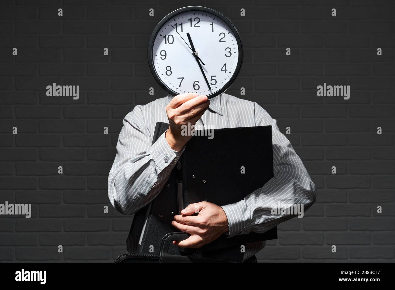 Businessman closeup portrait, he stands and shows the clock in front of ...
