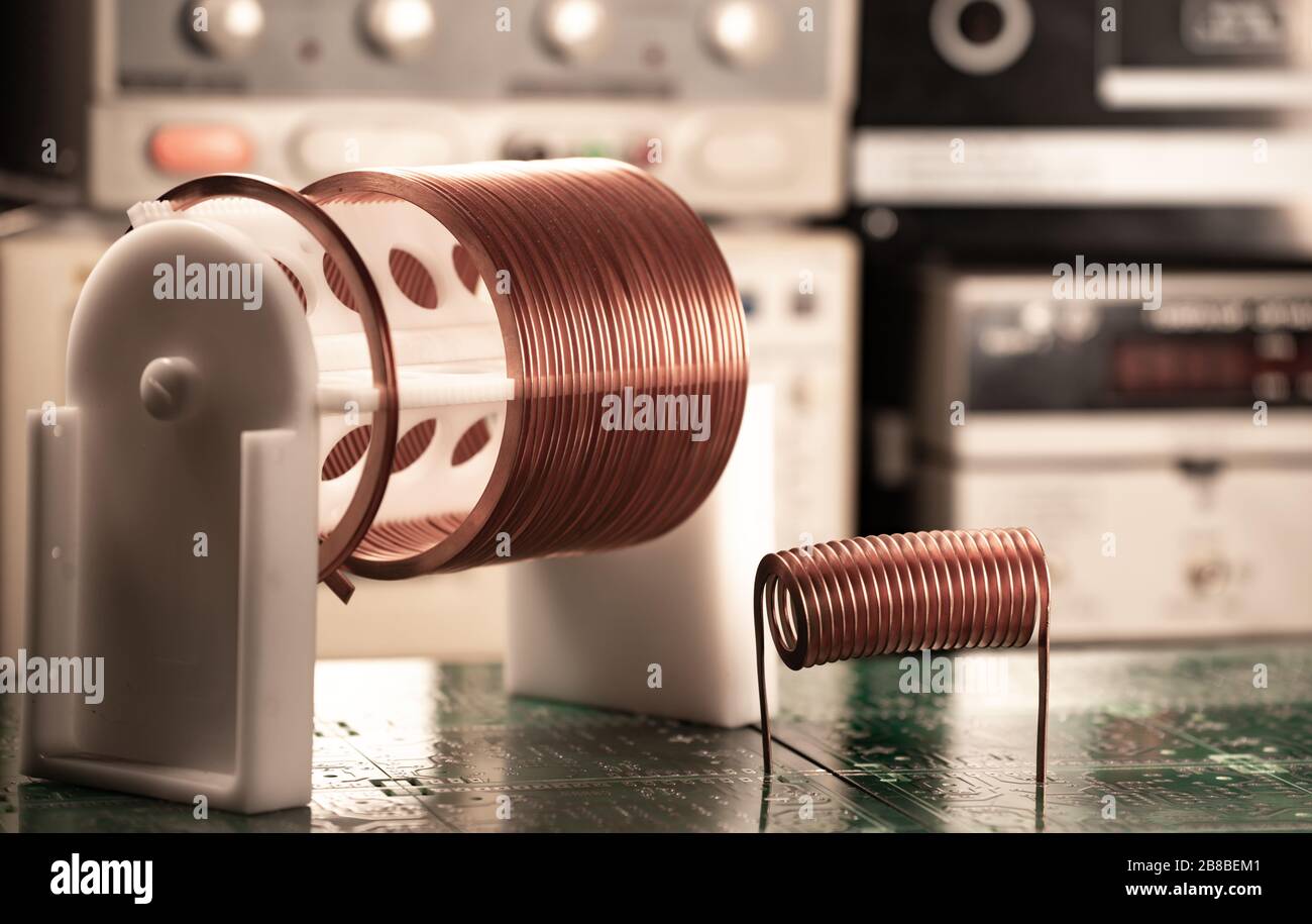Close-up large and small coils with copper wire stand on a green ...