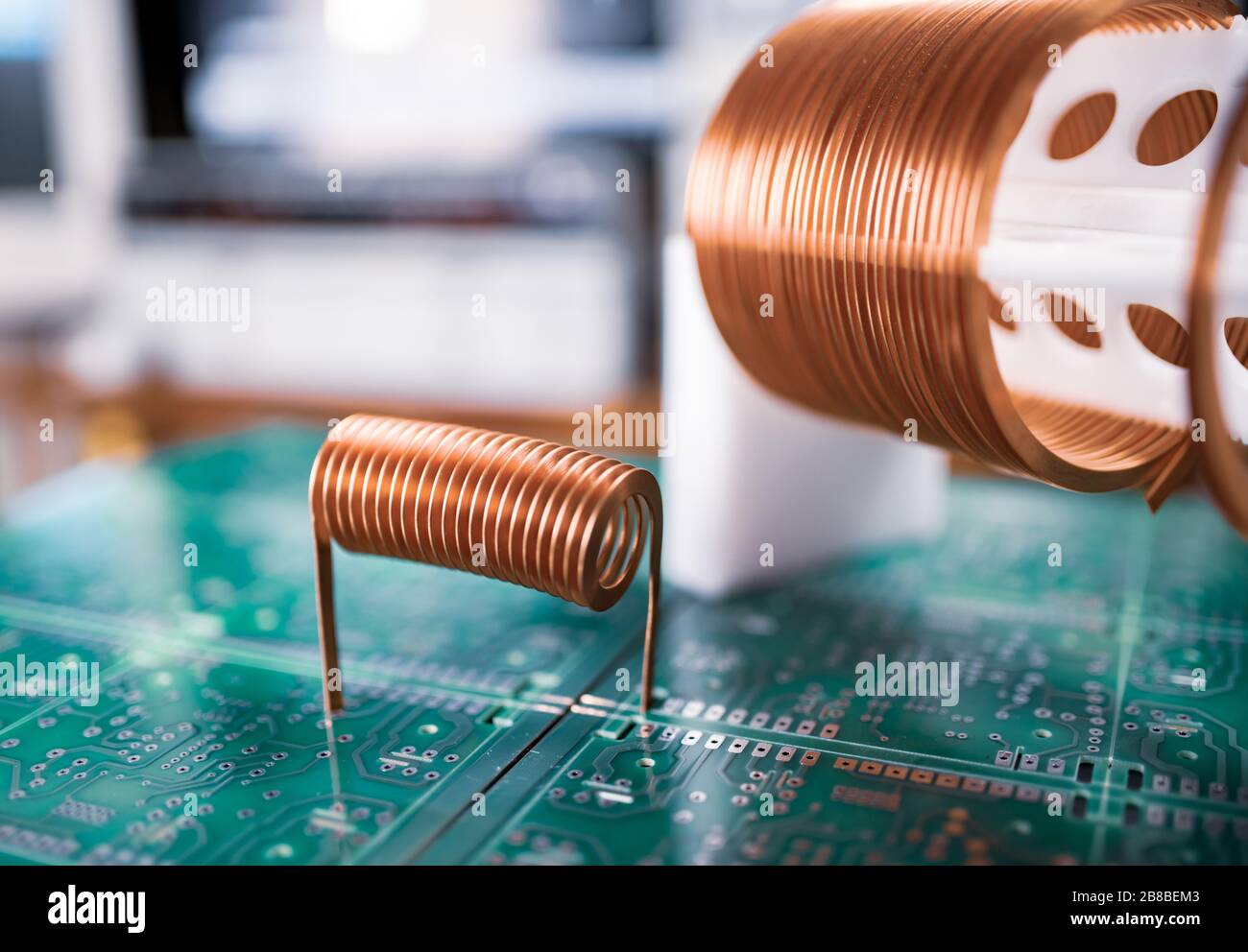 Close-up large and small coils with copper wire stand on a green ...