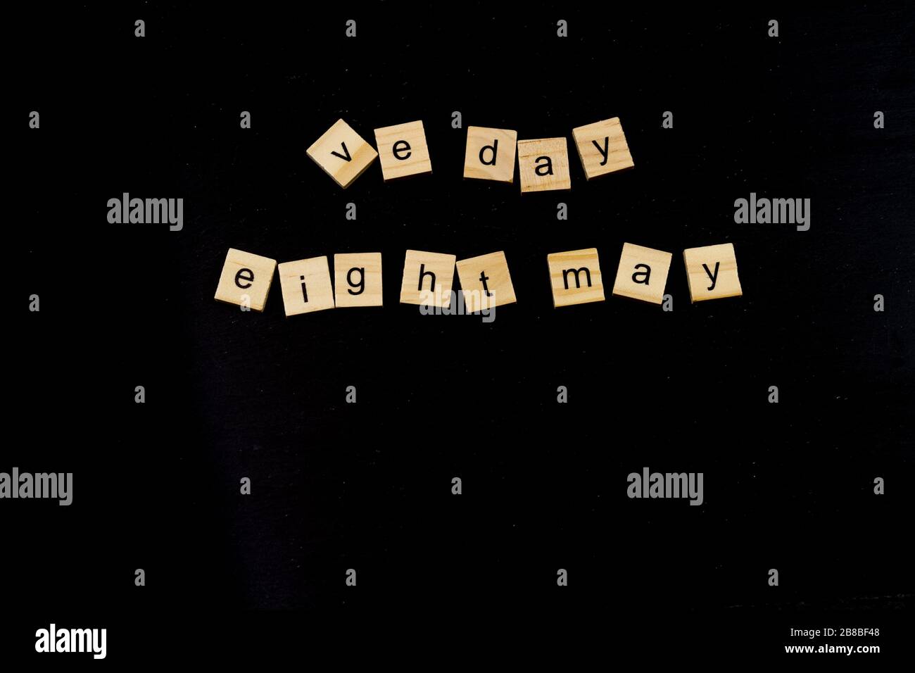 Children wood blocks lettering, jumbled scattered VE Day 2020 on black ...