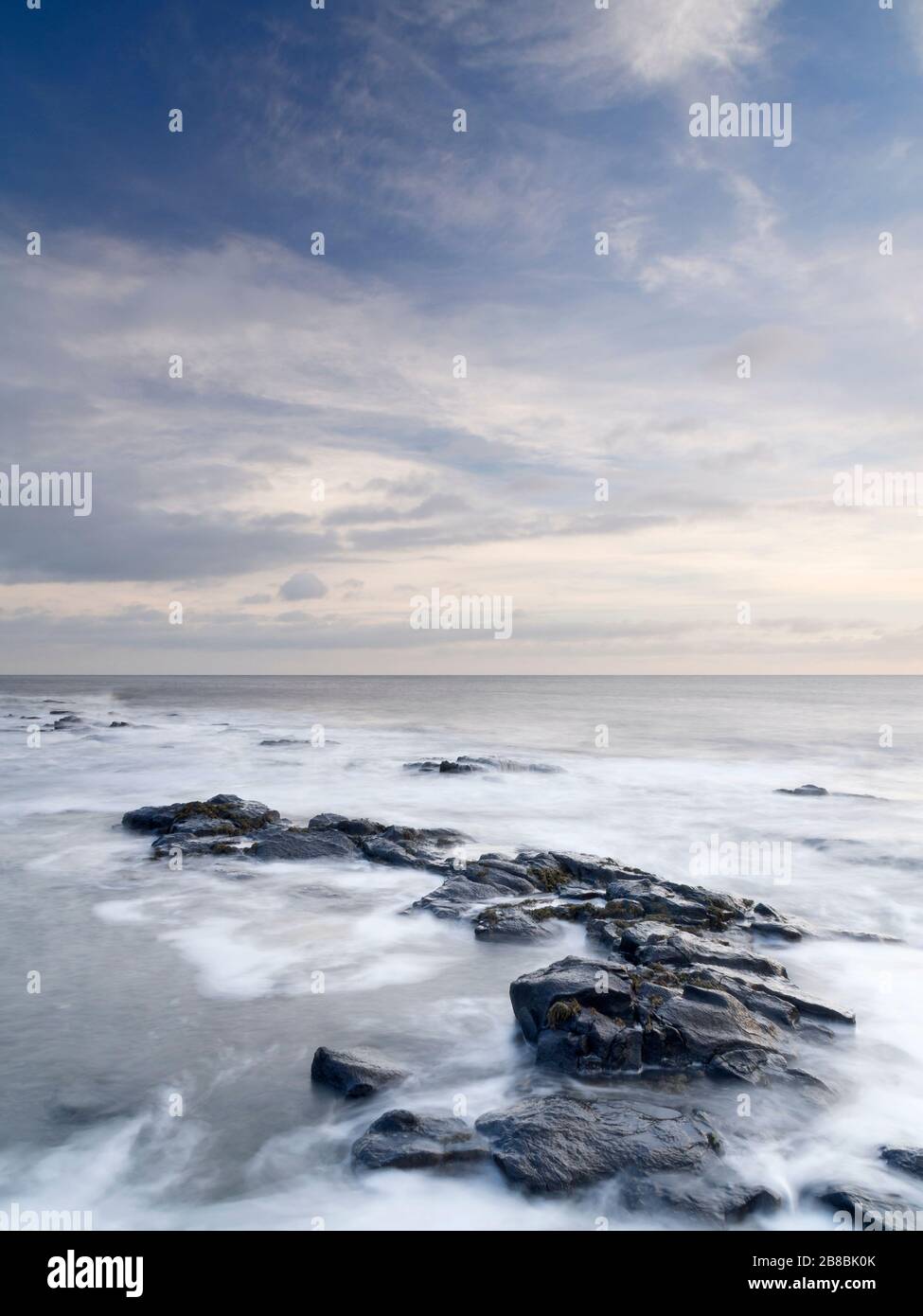 Water swirling around the rocks on the coastline at Craster ...