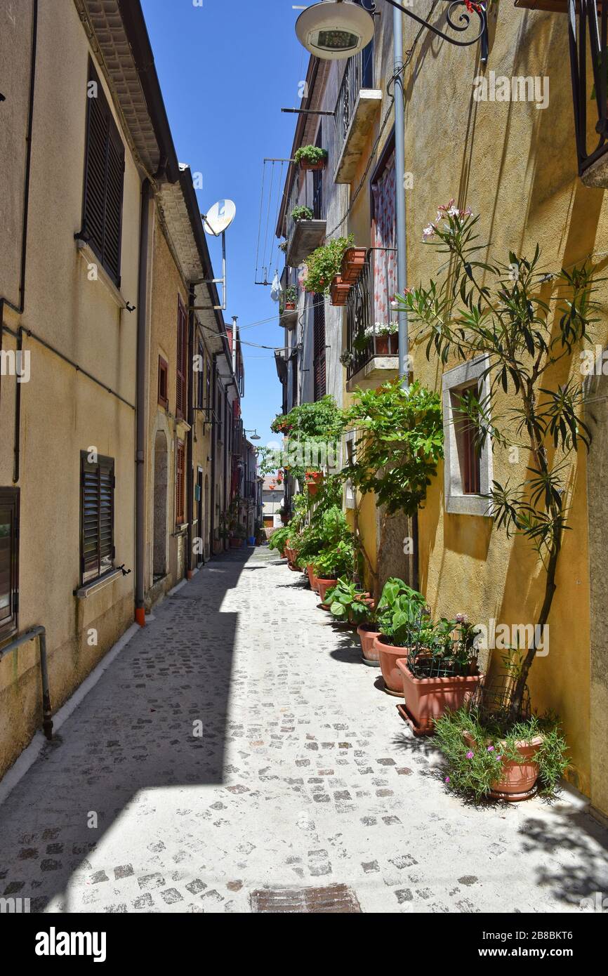 A narrow street between the houses of the medieval village of Nusco, in ...