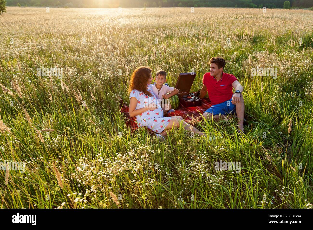 A happy family spends time together in nature. They are sitting on the ...