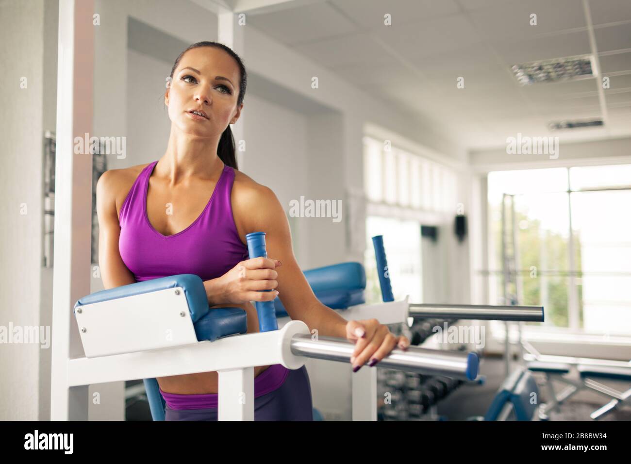 Front View Of Beautiful Athletic Lady Standing Near Gym Equipment For