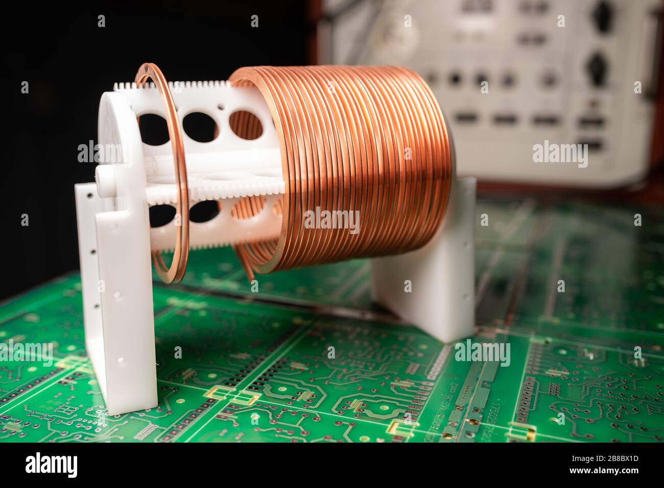 Close-up of a coil of copper wire standing on a large microcircuit ...