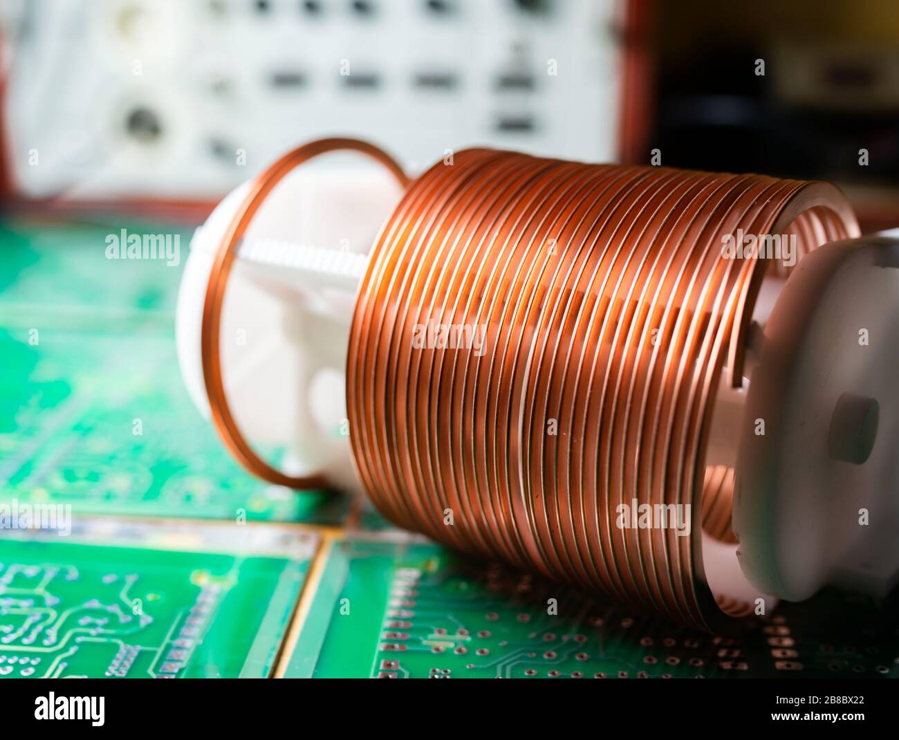 Close-up of a coil of copper wire standing on a large microcircuit ...