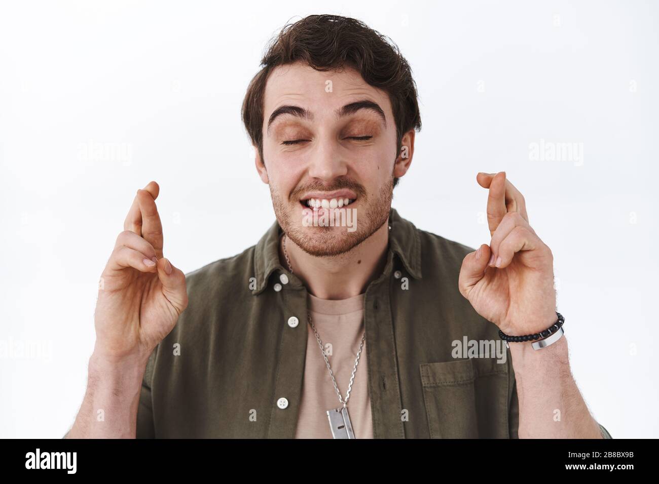 Close-up portrait of hopeful handsome guy wishing all best, close hands ...