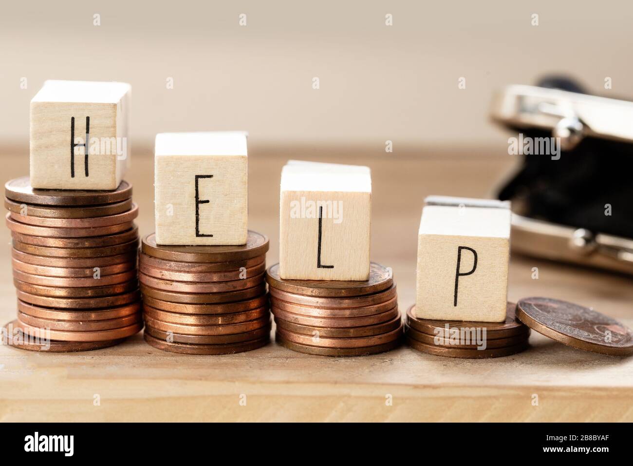 Wooden cubes with the word Help and pile of coins, money stairs ...