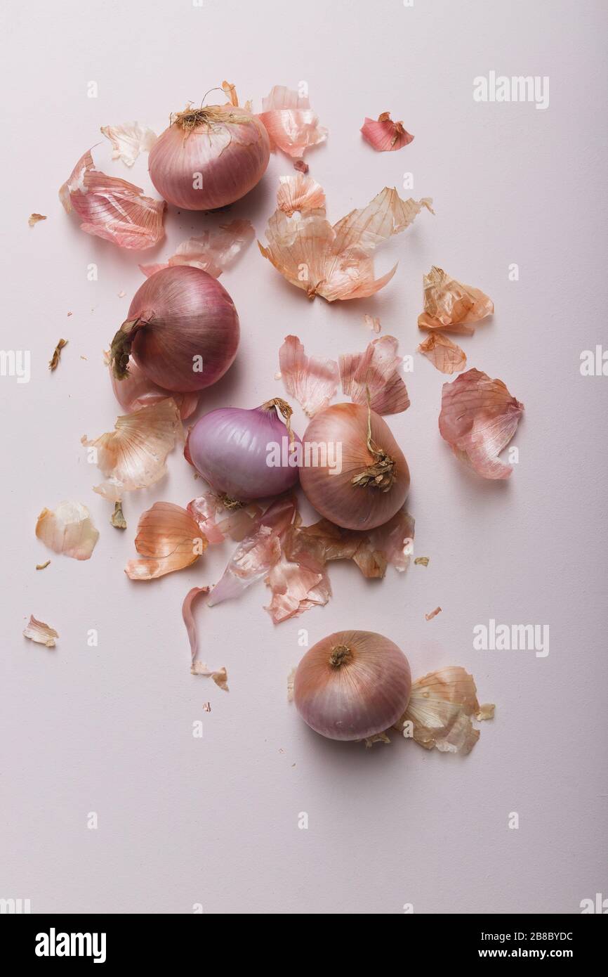 Many red onions, with onion peels on white background Stock Photo - Alamy