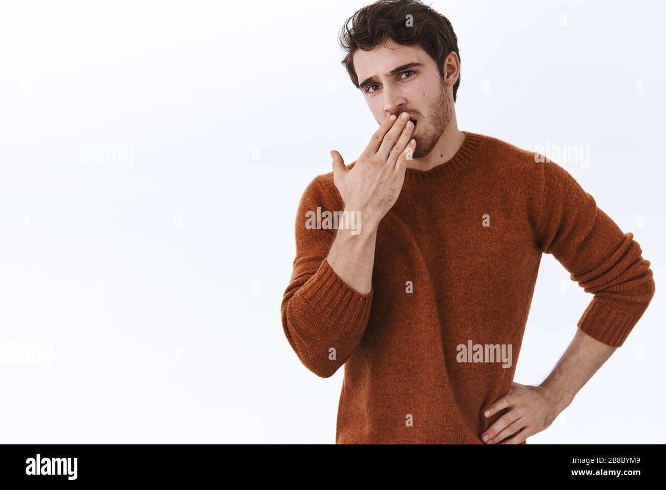 Uninterested young stylish man yawning as hear boring conversation ...