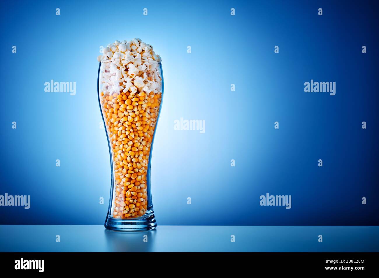 Beer glass filled with popcorn and corn kernels. Beer and popcorn snack ...