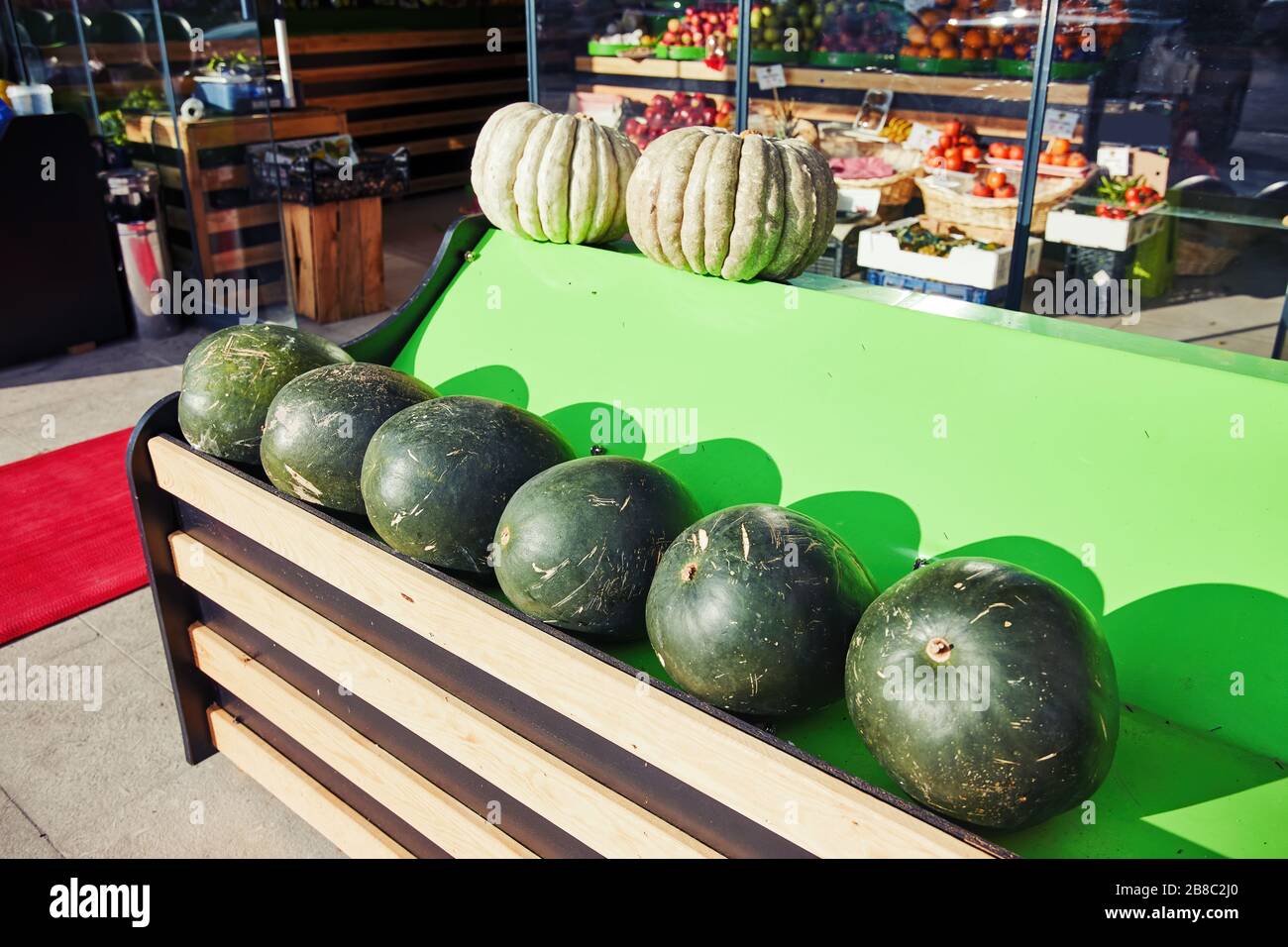Fresh watermelons and pumpkins on the outdoor stall of a grocery shop ...