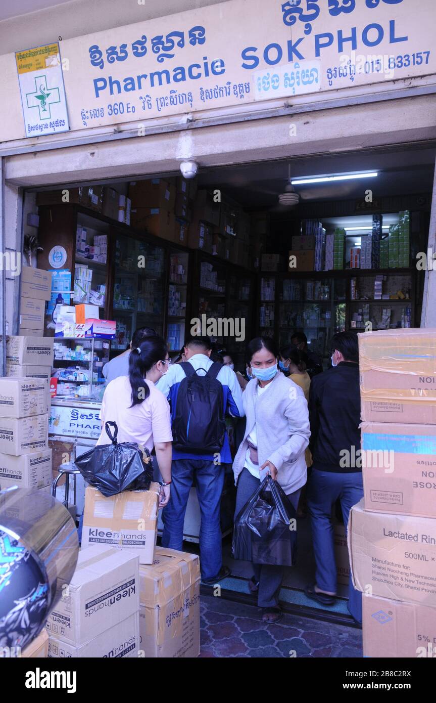 Cambodians, some w/ protective face masks, buy drugs at a crowded ...