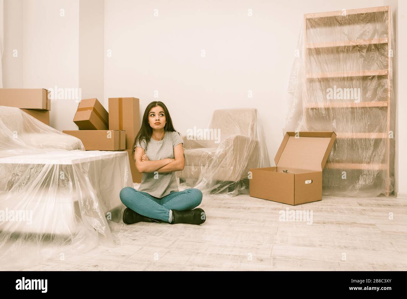 Female trying to be calm while moving in new flat Stock Photo - Alamy