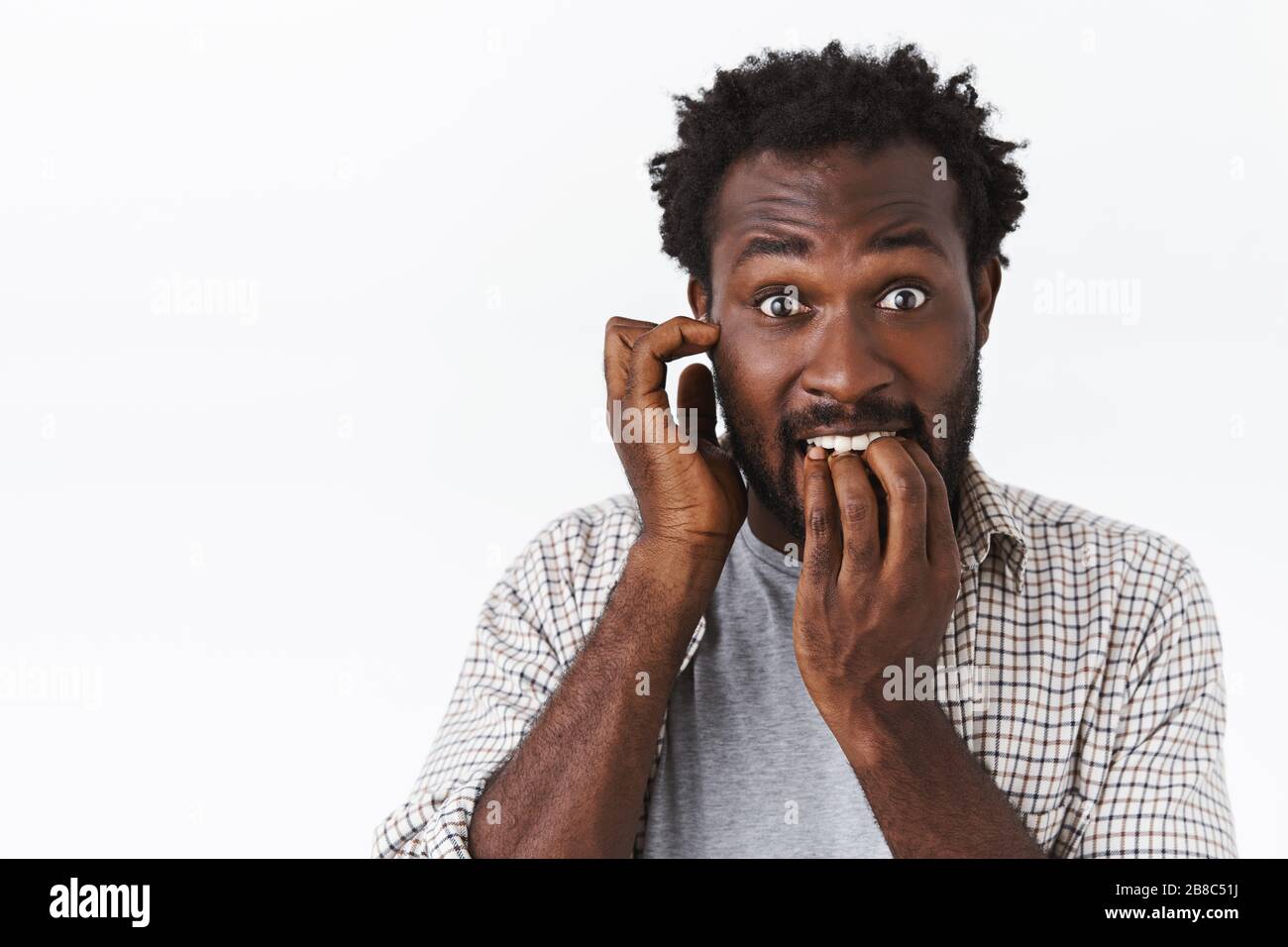 Embarrassed and worried bearded african-american guy feel panic, biting ...