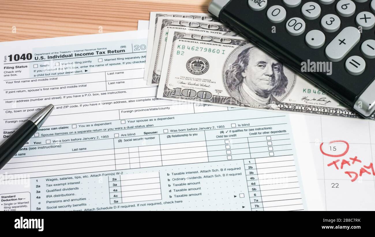 US 1040 tax return form with 100 usd dollar bills and calculator Stock ...