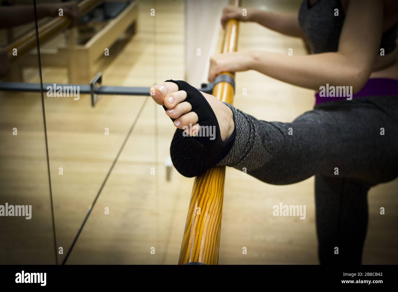Female dancer doing leg stretches on the ballet barre Stock Photo - Alamy