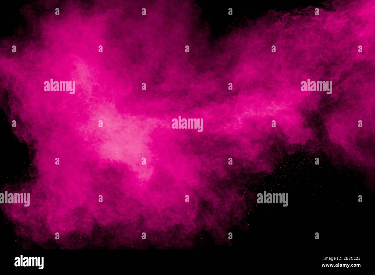 Abstract pink dust explosion on black background. Freeze motion of pink ...