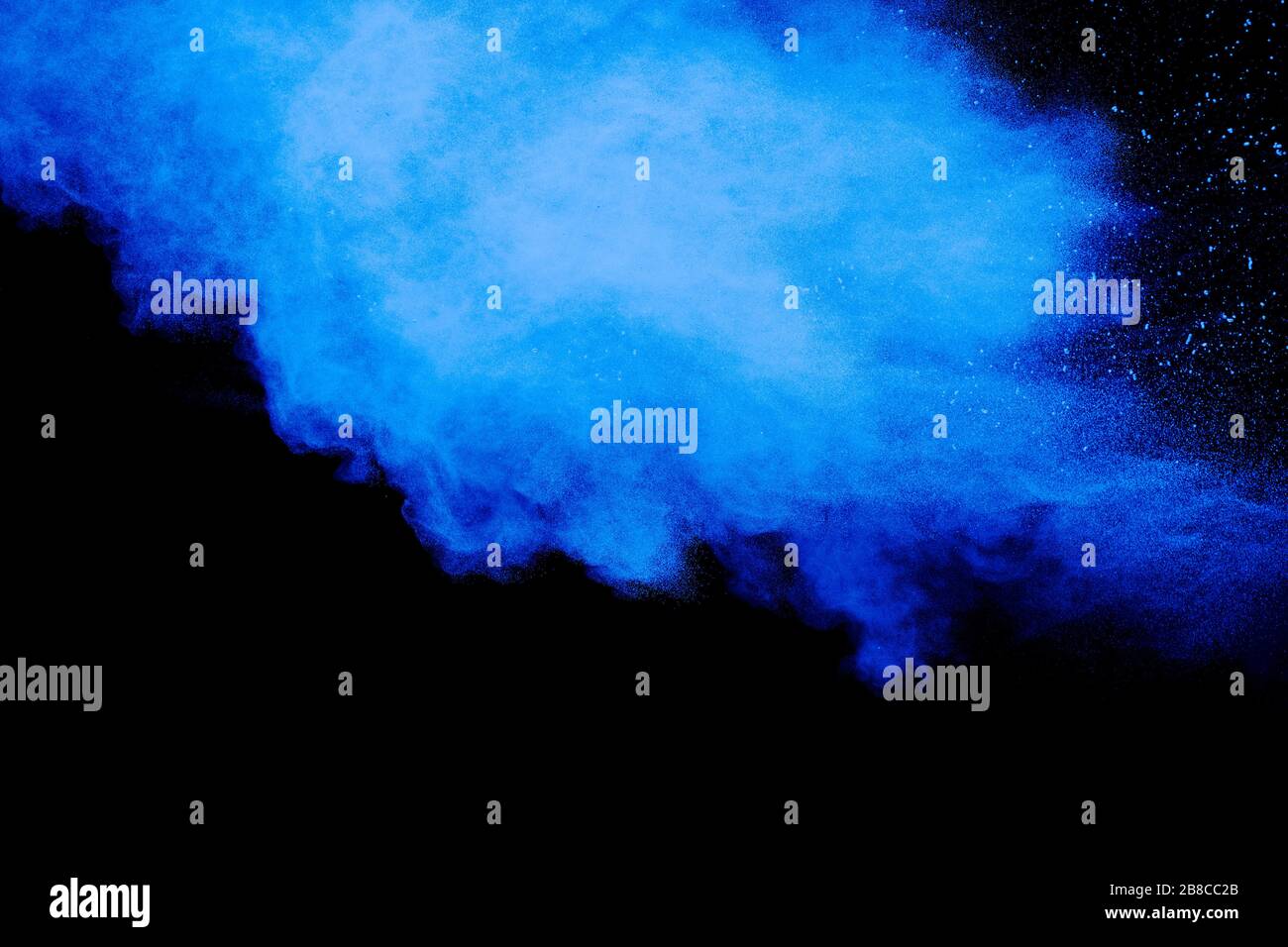 Blue dust explosion on black background. Freeze motion of color powder ...