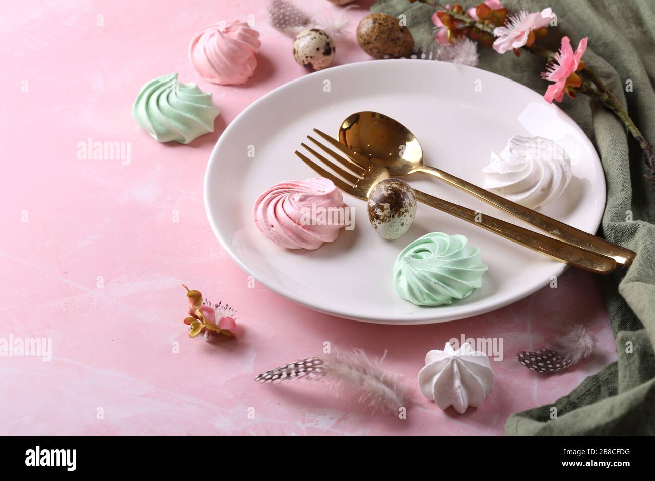 Easter still life table setting flowers and eggs on a pink background ...