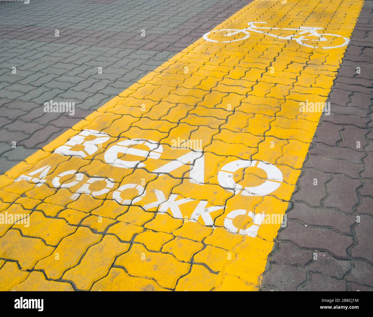 Marking of the bike path with yellow paint applied on the paving stones ...