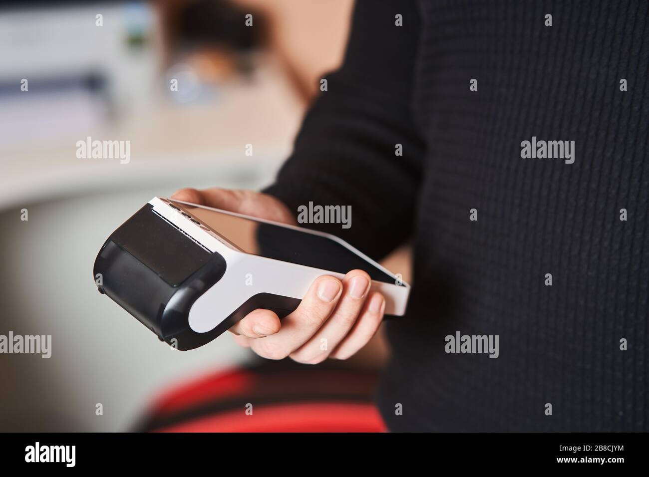 Bank terminal for contactless payment. Young man holds a terminal in ...